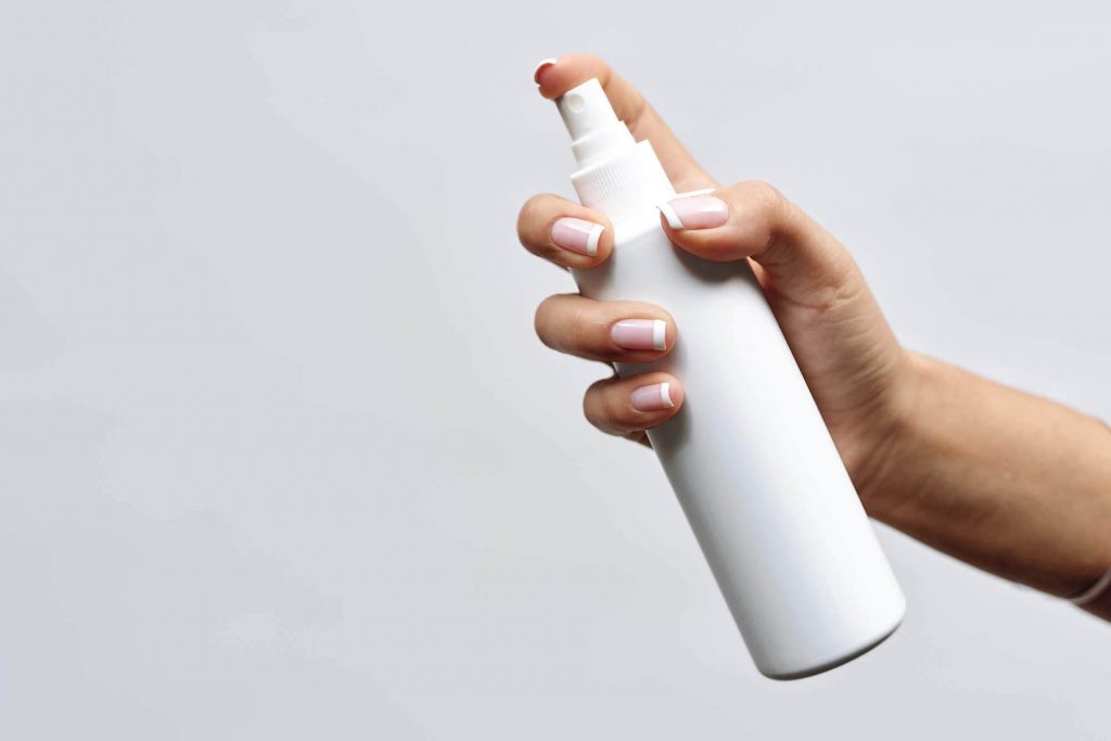 Hand Holding Spray Bottle Mockup for Branding - Package Mockups